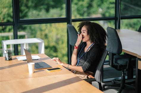 사무실에서 곱슬 머리 갈색 머리 여자가 야유하고 근무일 후 피곤함을 느낀다 20 24세에 대한 스톡 사진 및 기타 이미지