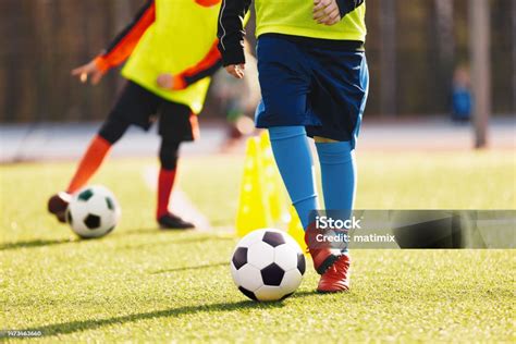 겨울 연습 캠프 기간 동안 훈련 훈련에서 축구 겨울 옷을 입은 아이들 슬라롬 훈련에서 클래식 축구공을 차는 두 선수 축구