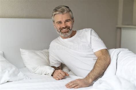 Happy Handsome Middle Aged Man Sitting In Bed Smiling Stock Photo Image Of Male Good