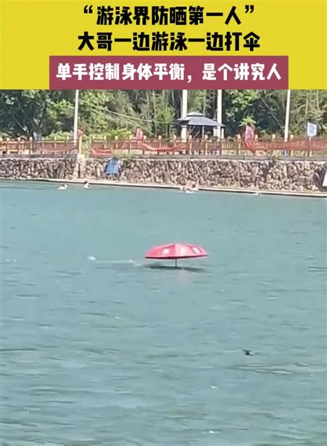 大哥一边游泳一边打伞单手控制身体平衡