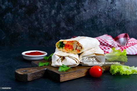 검은 배경에 맛 있는 샤 왈 마 샌드위치 부리토에 구운 닭고기와 채소 채소로 감싼 답니다 파히타 피타 빵 전통적인 중동 전채 요리 건강 한 음식 멕시코 요리를 제공 합니다