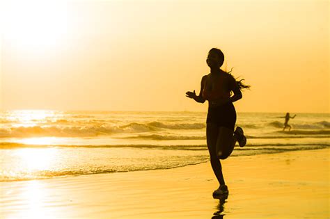 조깅 하 고 보건 의료 및 야외 활동에서 석양을 즐기는 아름 다운 해변에서 실행 피트 니스 운동에 운동 행복 하 고 매력적인 젊은 아프리카계 미국인 선수 여자의 실루엣