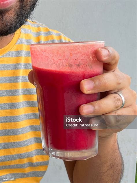 빨간색 딸기 스무디의 미국 식당 유리를 들고있는 인식되지 않은 남자의 클로즈업 이미지 과일 밀크 셰이크를 마시는 수염을 가진 남자 건강한 식습관 전경에 집중 빨강에 대한