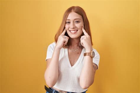 Young Redhead Woman Standing Over Yellow Background Smiling With Open
