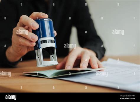 Man Border Control Worker Puts A Stamp In The Passport Tourism