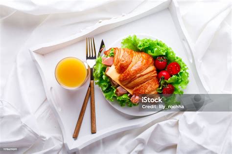 신선한 크루아상 샌드위치와 햄 치즈 체리 토마토 샐러드 잎 주스 오렌지 아침 식사 한 잔과 함께 침대 맛있는 베이킹 라이트 식사 0명에 대한 스톡 사진 및 기타 이미지