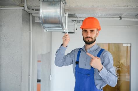 Hvac 작업자는 환기 및 에어컨 복사 공간을 위한 덕트 파이프 시스템을 설치합니다 프리미엄 사진