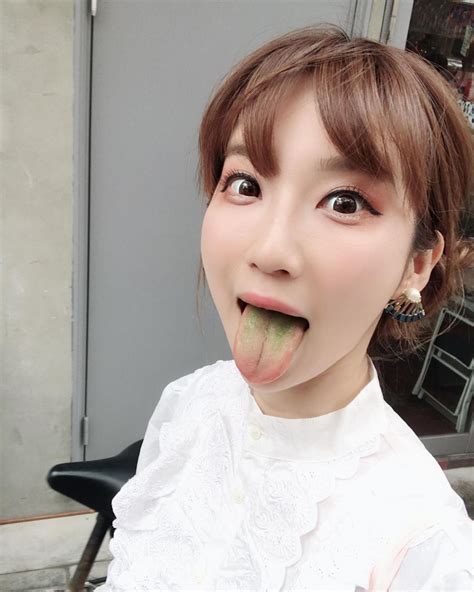 A Woman Sticking Her Tongue Out And Making A Funny Face With An Apple