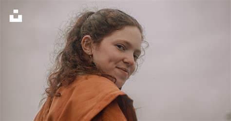 주황색 재킷을 입은 어린 소녀가 카메라를 향해 미소를 짓고 있다 사진 Unsplash의 무료 밴쿠버 이미지