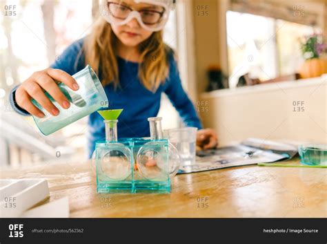Girl Doing Science Experiment Pouring Liquid Into Flask Stock Photo OFFSET