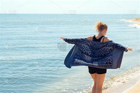 一个阳光明媚的下午，年轻女孩在海滩上散步