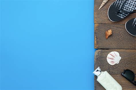 테이블 상단 보기 항목 여행 여름 휴가 배경 개념을의 공중 이미지 해변 여행을 여행 위한 평면 위치 필수 액세서리 블루 종이와 나무 판자에 구두와 패션 태양 안경 개념에