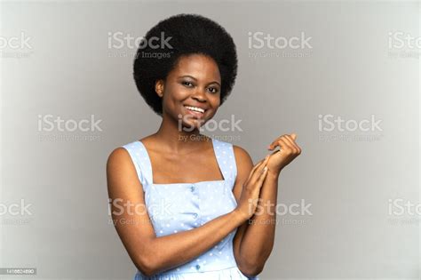 회색 배경에 스튜디오에 서있는 변덕스러운 머리카락을 가진 쾌활한 아프리카 계 미국인 여성 20 24세에 대한 스톡 사진 및 기타 이미지 20 24세 광대한 긍정적인