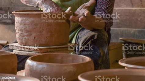 여자 격자 무늬 셔츠와 녹색 앞치마 아름 답게 갈색 점토의 깊은 그릇을 Sculpts 포터와 아름 다운 워크숍에서 포터의 바퀴에