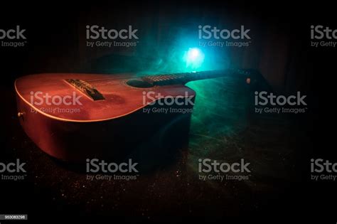 음악 개념입니다 연기와 함께 빛의 광선에서 어두운 배경 음향 기타 문자열 기타 닫습니다 선택적 초점입니다 불 효과 초현실적인 기타 Performing Arts Event에