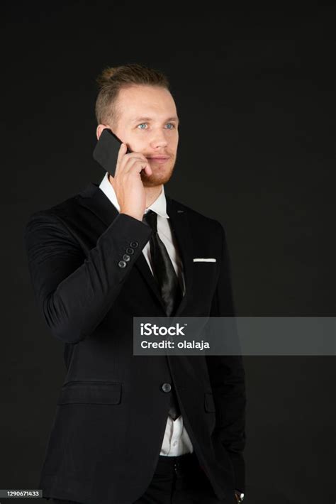 검은 색 배경에 고립 된 스마트 폰을 사용하여 검은 양복을 입은 젊은 스마트 자신감과 성공적인 사업가의 초상화 경영자에 대한 스톡 사진 및 기타 이미지 Istock