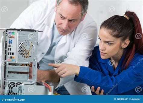 Happy Teacher And Young Woman Fixing Computer In Classroom Stock Image