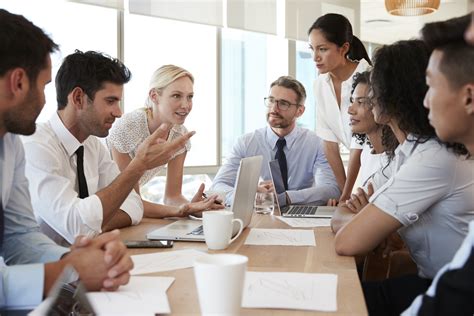group of businesspeople meeting around table in office purdue university global academic