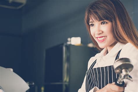 중소 기업 소유자는 커피가 게에서 카운터에 서 서 여성 바리 스타 앞치마 미소를 입고 카페에 바 식품 서비스 레스토랑 개념입니다