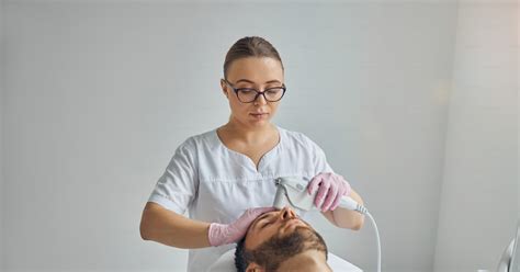 미용 클리닉에서 레이저 얼굴 치료를 받는 동안 데이베드에 누워 있는 면도하지 않은 청년 사진 Unsplash의 라이프 스타일 이미지