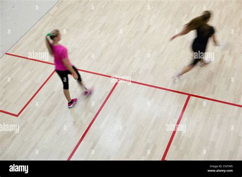 Two Female Squash Players In Fast Action On A Squash Court Motion Blurred Image Color Toned