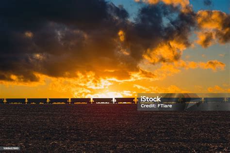 미국 시골에 있는 필드의 지평선 통과 하는 화물 열차 일몰 빛과 폭풍우 치는 하늘 배경입니다 기차에 대한 스톡 사진 및 기타