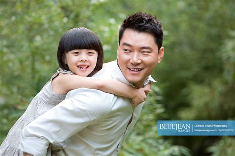 Chinese Father And Daughter Having Fun In Garden High Res Stock Photo