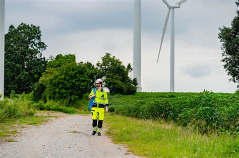 구름 낀 날 풍력 터빈 근처의 시골길을 따라 걷고 있는 안전 장비를 착용한 작업자 건설 산업에 대한 스톡 사진 및 기타 이미지 건설 산업 계획 공학 Istock