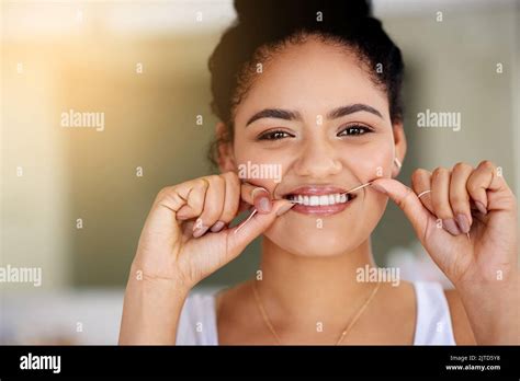 Flossing For The Love Of Her Teeth Portrait Of An Attractive And Happy Young Woman Flossing Her