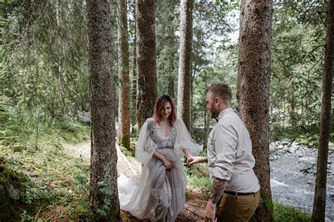 美丽幸福的新婚夫妇手牵着手走在高山森林湍急的河流附近