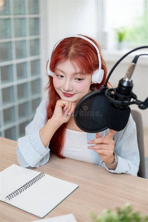 A Beautiful Asian Female Podcaster Or Radio Host In Red Curly Hair Is