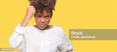 이상의 겨울 스웨터를 입고 아름 다운 젊은 아프리카계 미국인 여자 절연 배경 화와 좌절과 분노와 함께 외치는 동안 분노 주먹 미친 높이 분노와 공격적 개념 감정에 대한 스톡