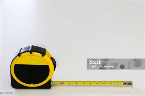 검은색과 노란색 개폐식 줄자 흰색 배경의 바닥 길이에 10cm로 고정되어 길이 너비 및 높이를 측정하는 데 유용한 도구입니다 정확성 및 정밀도 개념 0명에 대한 스톡 사진