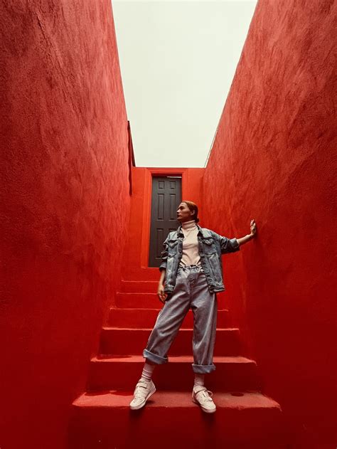 검은 재킷과 파란색 데님 청바지를 입은 남자가 갈색 콘크리트 벽 옆에 서 있다 사진 Unsplash의 무료 스타일 이미지