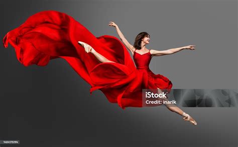 발레리나 댄스 레드 드레스 점프 스플릿의 발레 댄서 발레리나 신발을 신고 실크 가운을 입고 춤을 추는 여성 회색 스튜디오 배경 위로 바람에 날아 다니다 춤에 대한 스톡 사진
