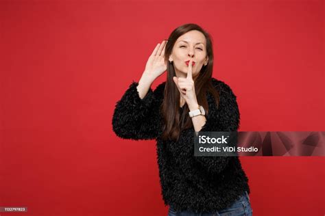 젊은 여자는 입술 쉿 제스처에 손가락으로 조용 하 게 자장을 말하고 빨간 벽 배경에 고립 된 귀 근처 손으로 청력을 도청 사람들은 진심으로 감정 라이프 스타일 개념입니다