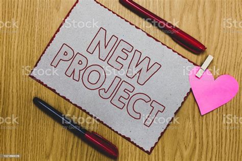 필기 텍스트는 새 프로젝트를 작성 합니다 개별 기업 특정 달성 하기 위해 계획을 의미 하는 개념 목표 조각 종이 옷 핀 심장 마커 낭만적인 메시지 나무 테이블을 잡고