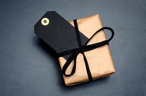 검은 색 배경 및 가격 레이블입니다 블랙 프라이데이 영업 개념입니다 공간을 복사합니다 재활용 된 갈색 종이에서 검은 종이 라벨과 선물 상자 블랙 프라이데이 세일 컨셉