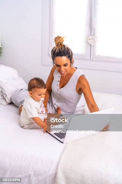 젊은 백인 어머니와 그녀의 아들과 함께 침대 위에 방에 가족과 화상 통화를 하면서 1년도 채 되지 않아 마십니다 공증19 전염병의 감금에 조부모와의 통신 어머니에 대한 스톡