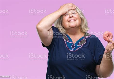 수석 플러스 크기 격리 된 배경 위에 백인 여자 먹는 설탕 도넛으로 스트레스 분노와 좌절 수치심과 깜짝 얼굴로 충격 을된 머리에 손을 두려워 하 고 실수에 대 한 화가