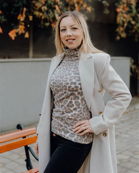 무료 사진 보도에서 베이지색 코트를 입고 포즈를 취하고 있는 화려한 금발 여성의 초상화