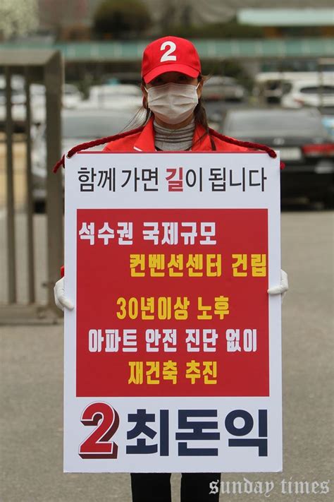 최돈익 후보 공약 팻말을 들고 있는 선거운동원 선데이타임즈