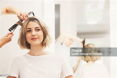 이발소 이발소 방에서 고객 서비스 미용 드레스 만들기 미용실에서 사랑스러운 젊은 여성을 위한 미용사 숙녀 컬링 헤어스타일 헤어스타일 라이프스타일의 개념 광고문안 공간 복사