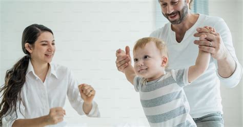 백인 사랑하는 부모는 침실의 침대에서 아기 아이와 놀고 있습니다 행복한 가족 매력적인 아름다운 젊은 커플 아빠와 엄마는 귀여운 유아 유아 아들과 함께 춤을 추며 기상 후