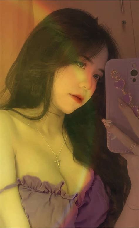 A Woman With Long Dark Hair Is Looking At Her Cell Phone While Wearing