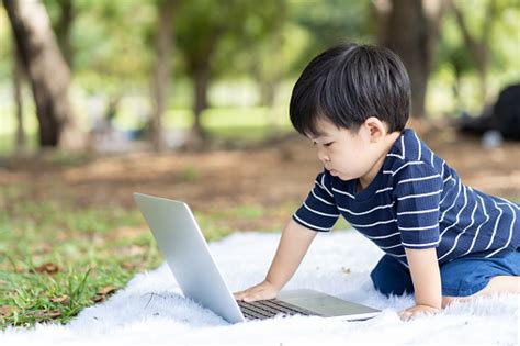 공원에서 노트북 컴퓨터로 배우고 사용하고 놀고 사용하는 행복한 아시아 의 어린 소년 재미 즐길 노트북 컴퓨터와 함께 휴식을 취하는 아이 어린이 놀이 학습 및 교육 개념 2