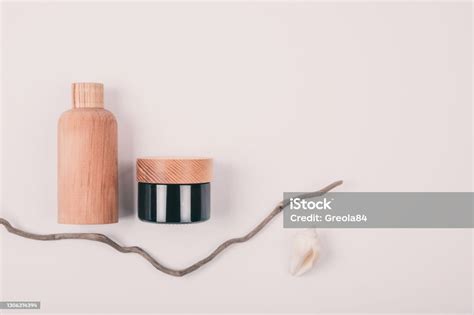 유목이 있는 베이지 색 파스텔 배경에 스킨케어 화장품을 위한 목재 및 유리 병 용기 빈 모형 공간을 복사합니다 0에 대한 스톡