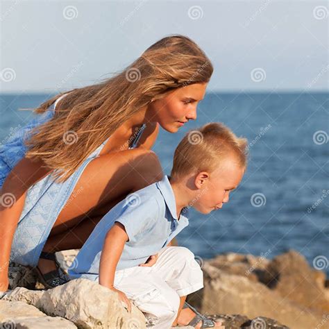 Happy Cute Big Sister And Little Brother Sitting On Beach Stock Image