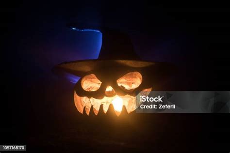 할로윈 개념입니다 잭오랜 턴 미소 그리고 파티 밤 무서운 눈 마녀 모자에 진한 안개 배경에서 무서운 호박의 보기를 닫습니다 선택적 초점입니다 0명에 대한 스톡 사진 및 기타