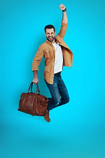 푸른 배경에 호버링하는 동안 행복한 젊은 남자의 미소와 몸짓의 전체 길이 가방에 대한 스톡 사진 및 기타 이미지 가방 근육질 남자 긍정적인 감정 표현 Istock